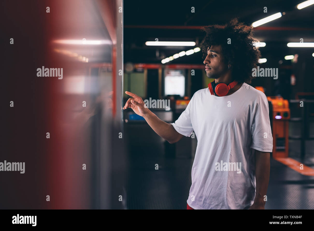 Young man buying train ticket at station Stock Photo - Alamy