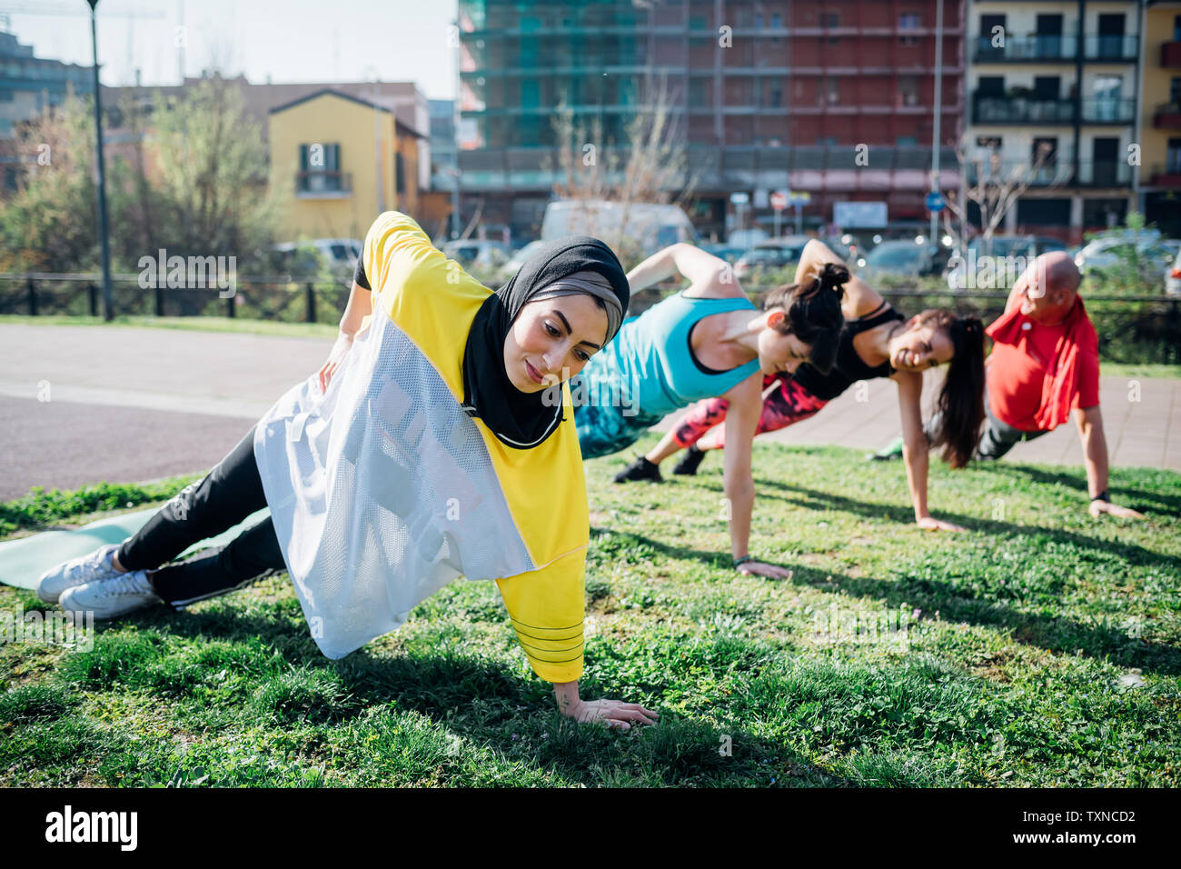 Calisthenics class at outdoor gym, women and man practicing sideways ...