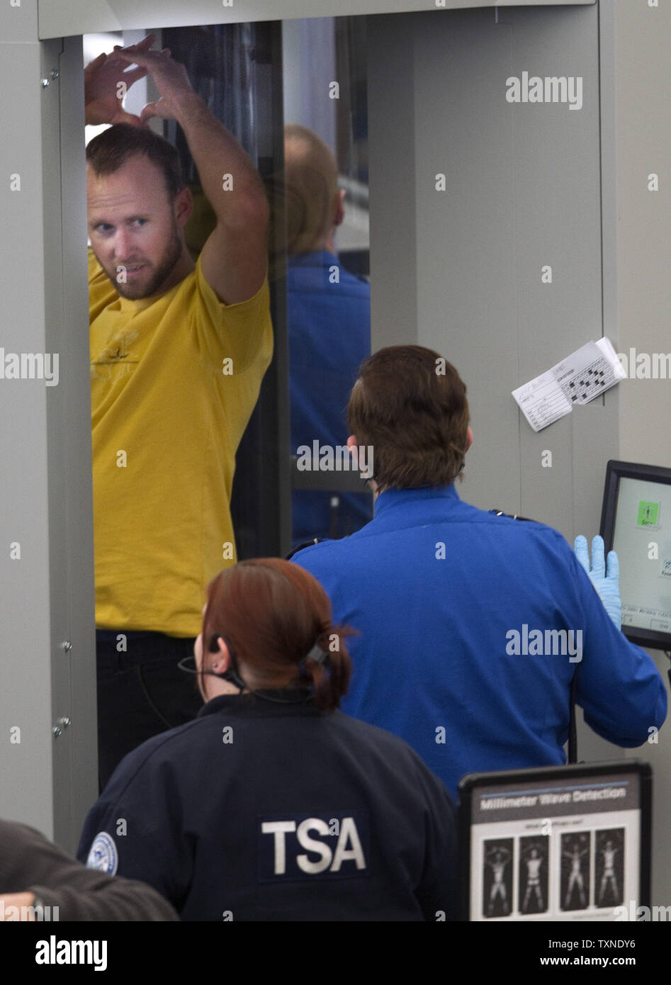 Transportation Security Administration (TSA) agents conduct a full-body ...