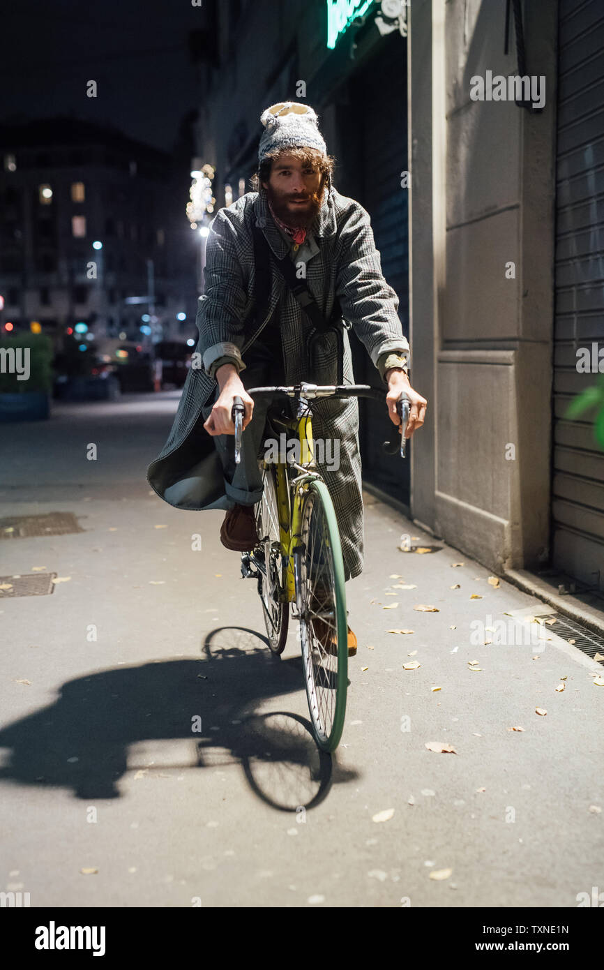 Bearded young man riding bicycle on pavement Stock Photo - Alamy