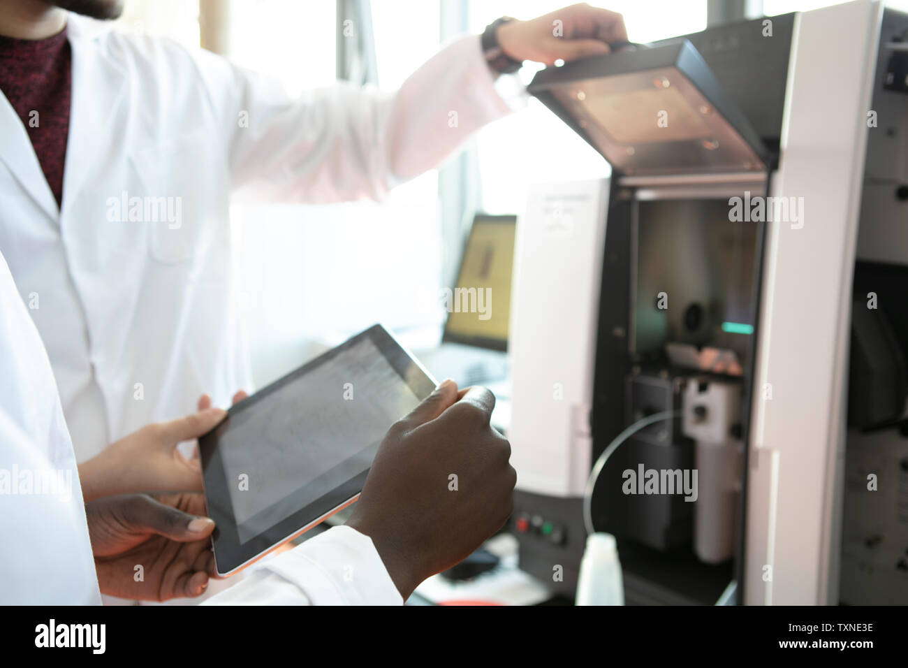 Young female and male scientists using digital tablet in laboratory ...