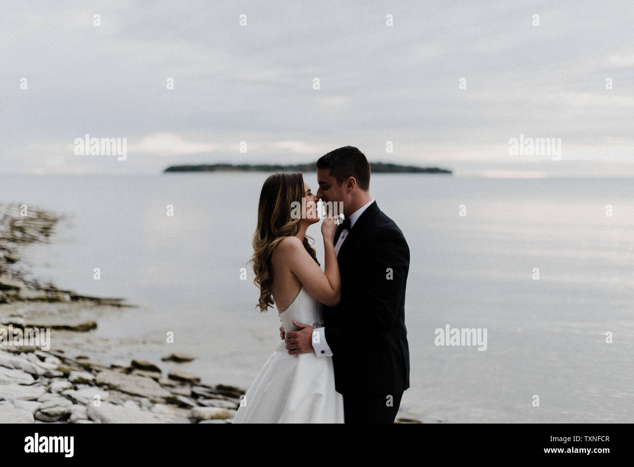 Romantic young bride and groom face to face on lakeside Stock Photo - Alamy