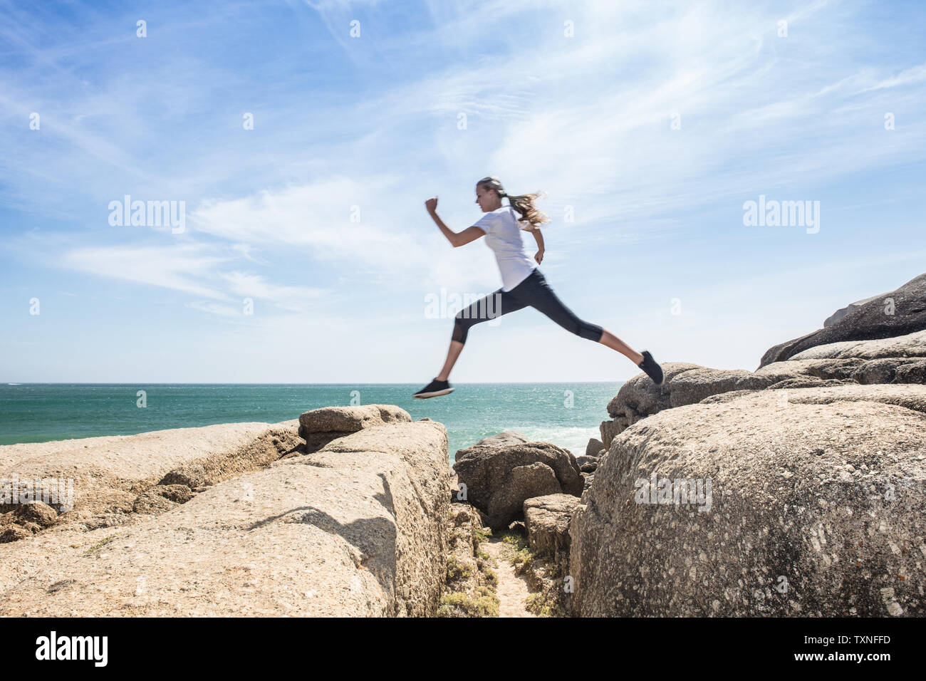 Female runner jumping rocks hi-res stock photography and images - Alamy