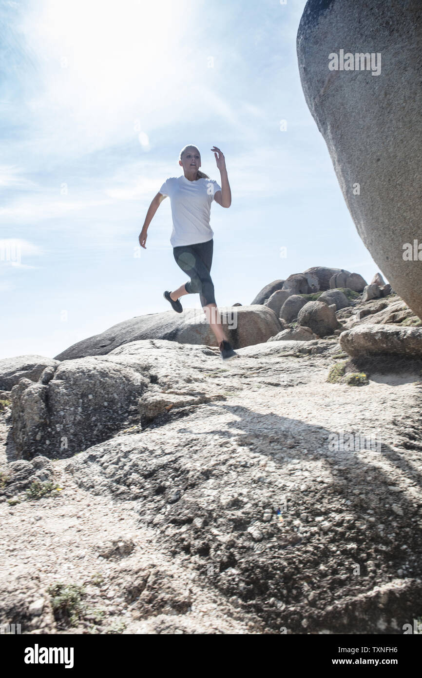 Woman running on beach rocks hi-res stock photography and images - Alamy