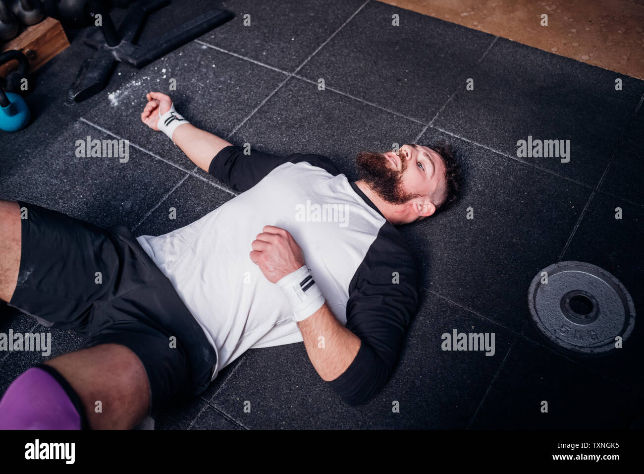 Exhausted young man taking break in gym Stock Photo - Alamy Exhausted young man taking break in gym Stock Photo - Alamy