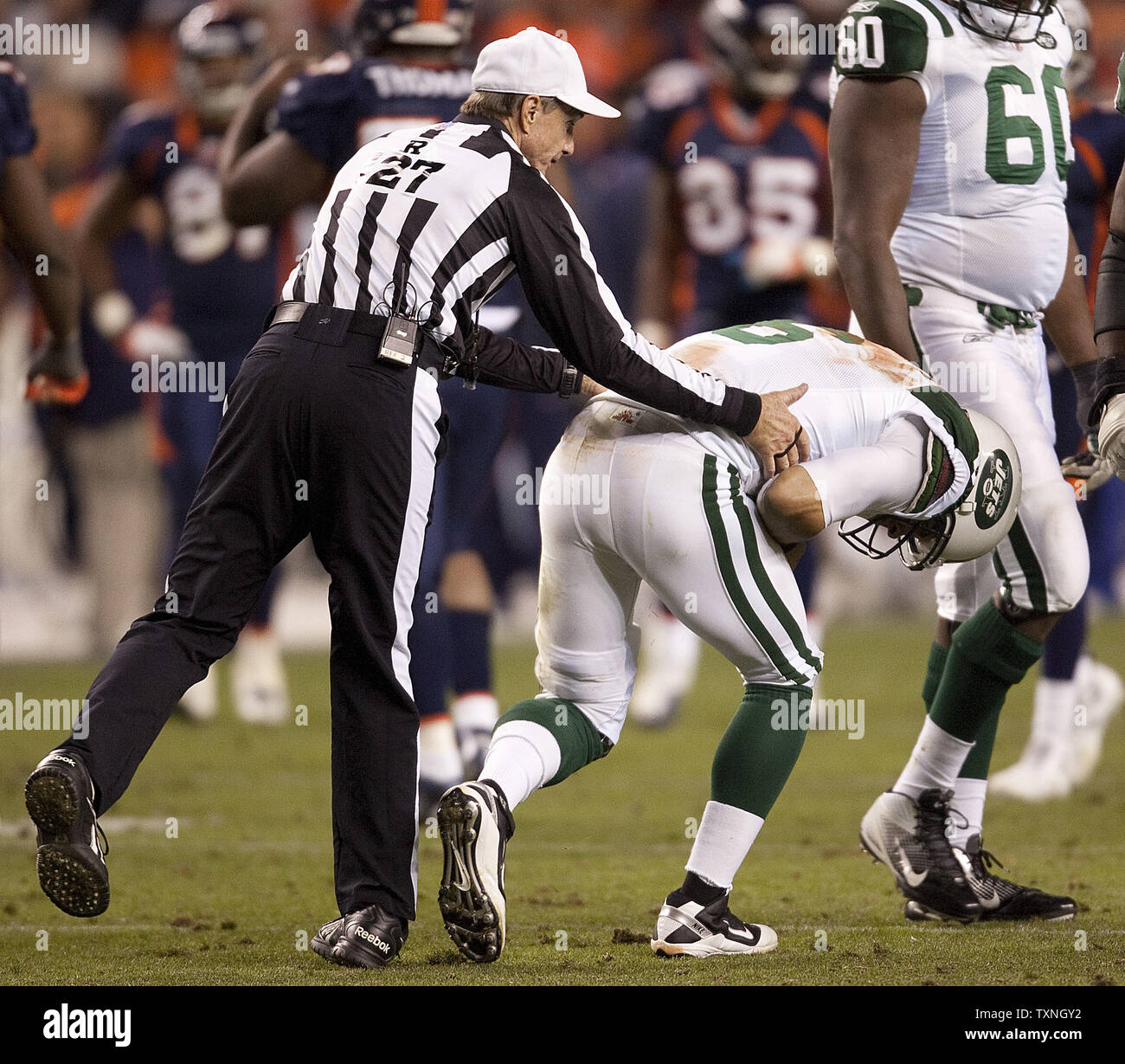 Referee Bill Leavy helps New York Jets quarterback Mark Sanchez after ...