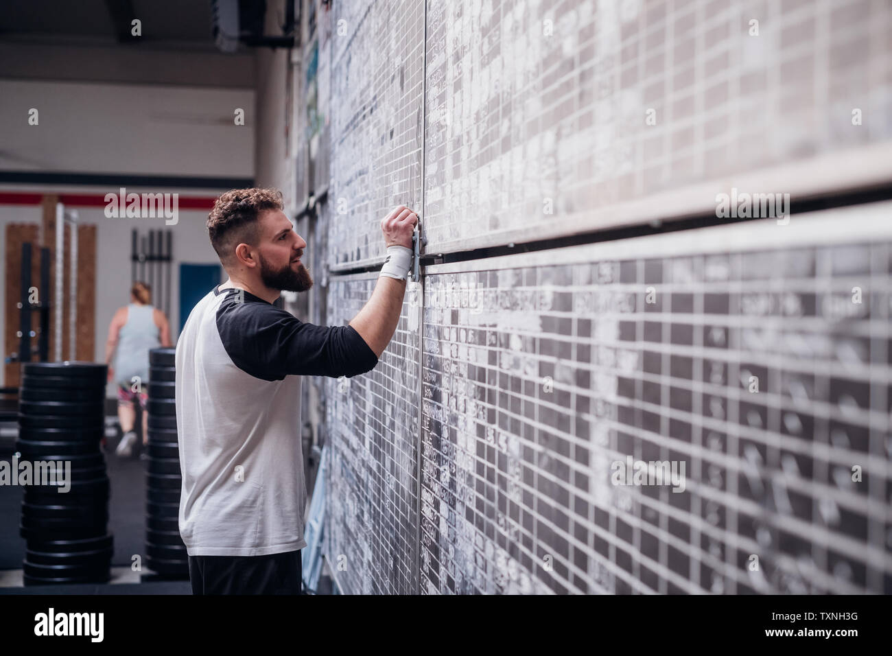 Young man writing on scoreboard in gym Stock Photo - Alamy