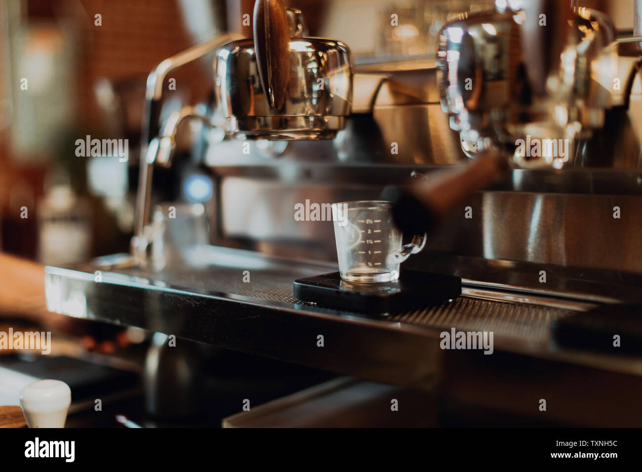 Empty measuring jug on coffee machine stand in cafe Stock Photo - Alamy