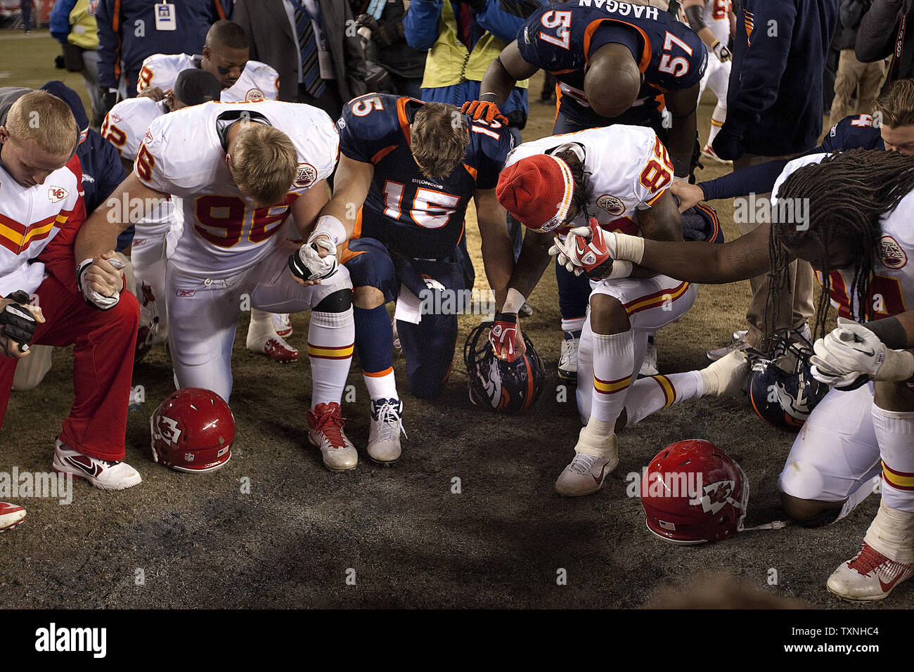 Denver Broncos quarterback Tim Tebow (15) kneels in prayer with players ...