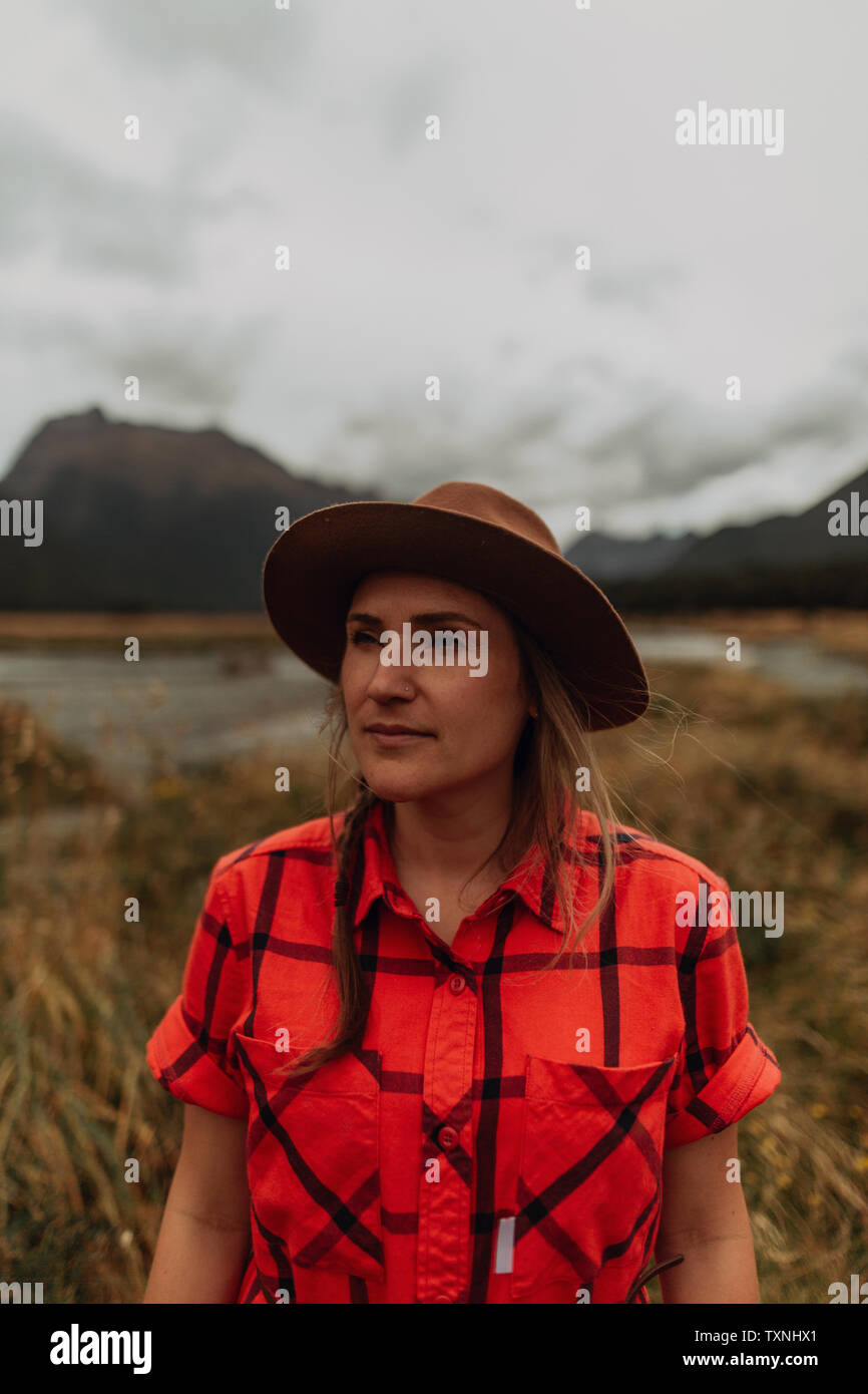Woman exploring wilderness by lake, Queenstown, Canterbury, New Zealand ...