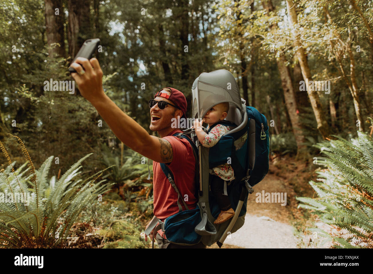 Father with baby taking selfie in forest, Queenstown, Canterbury, New ...