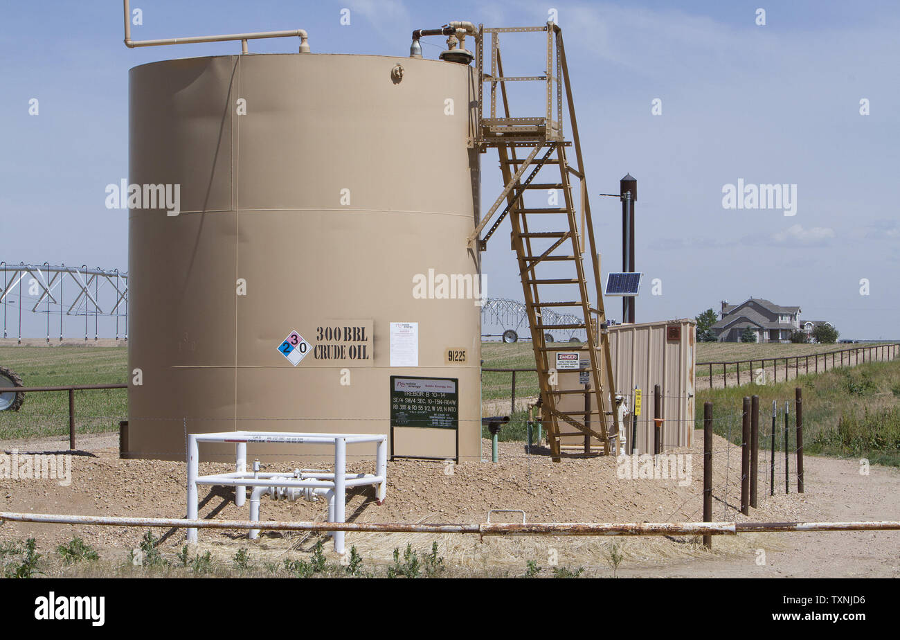 A oil pumping and storage unit sits at the beginning of a long driveway ...