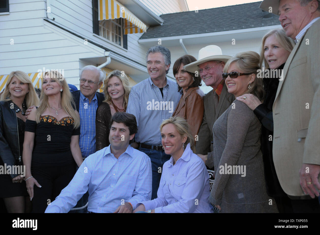 Members of the cast pose for a photo with fans during the Dallas 30th ...