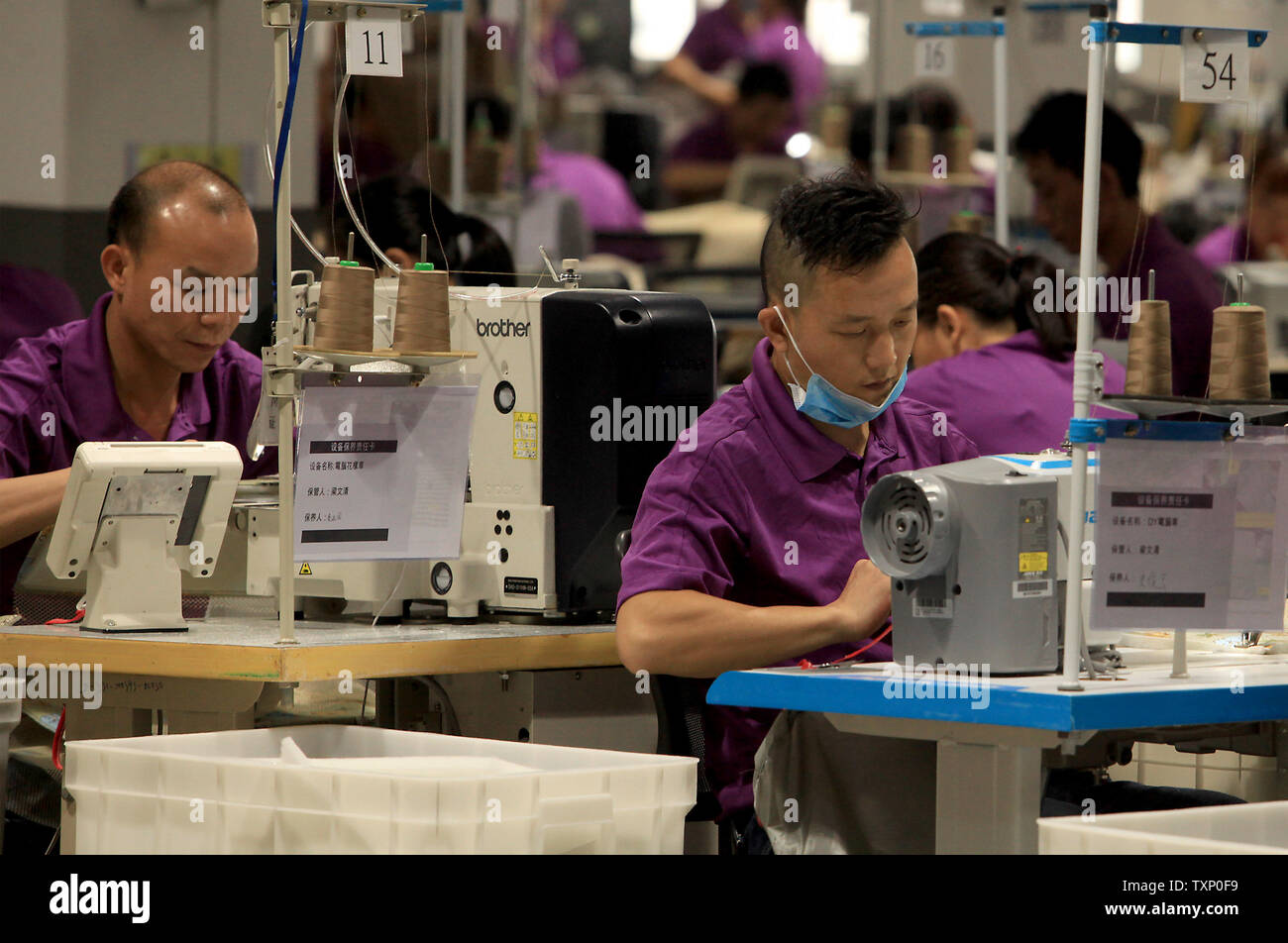 Chinese workers assemble parts of child products, including car seats ...