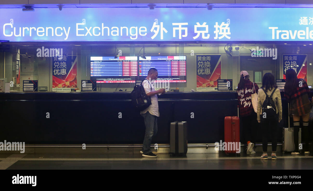 Passengers exchange money after arriving at Dunhuang's airport, Gansu ...