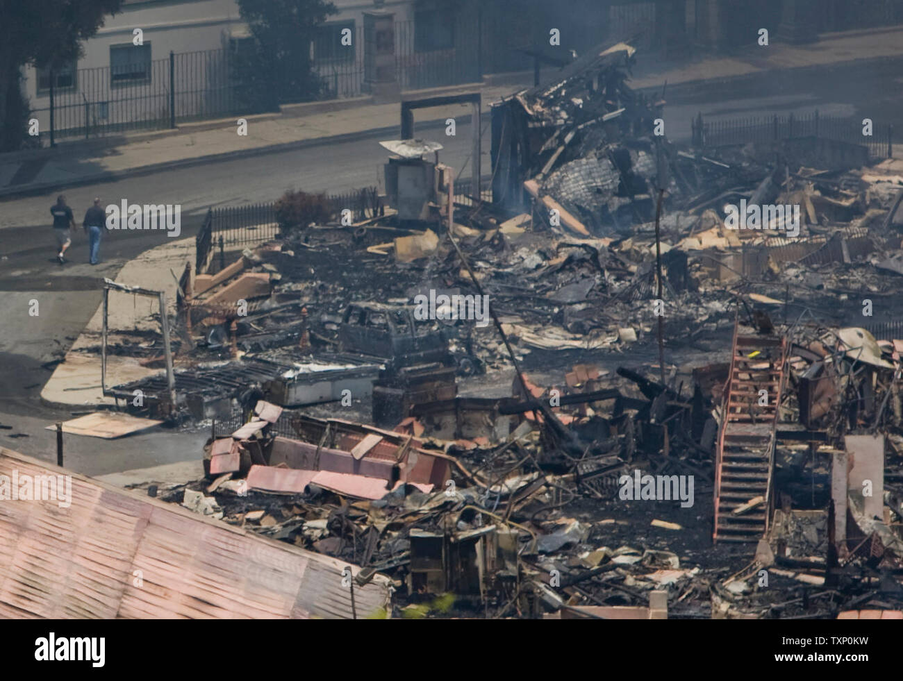 Security officials survey the remains of a fire that destroyed parts of ...