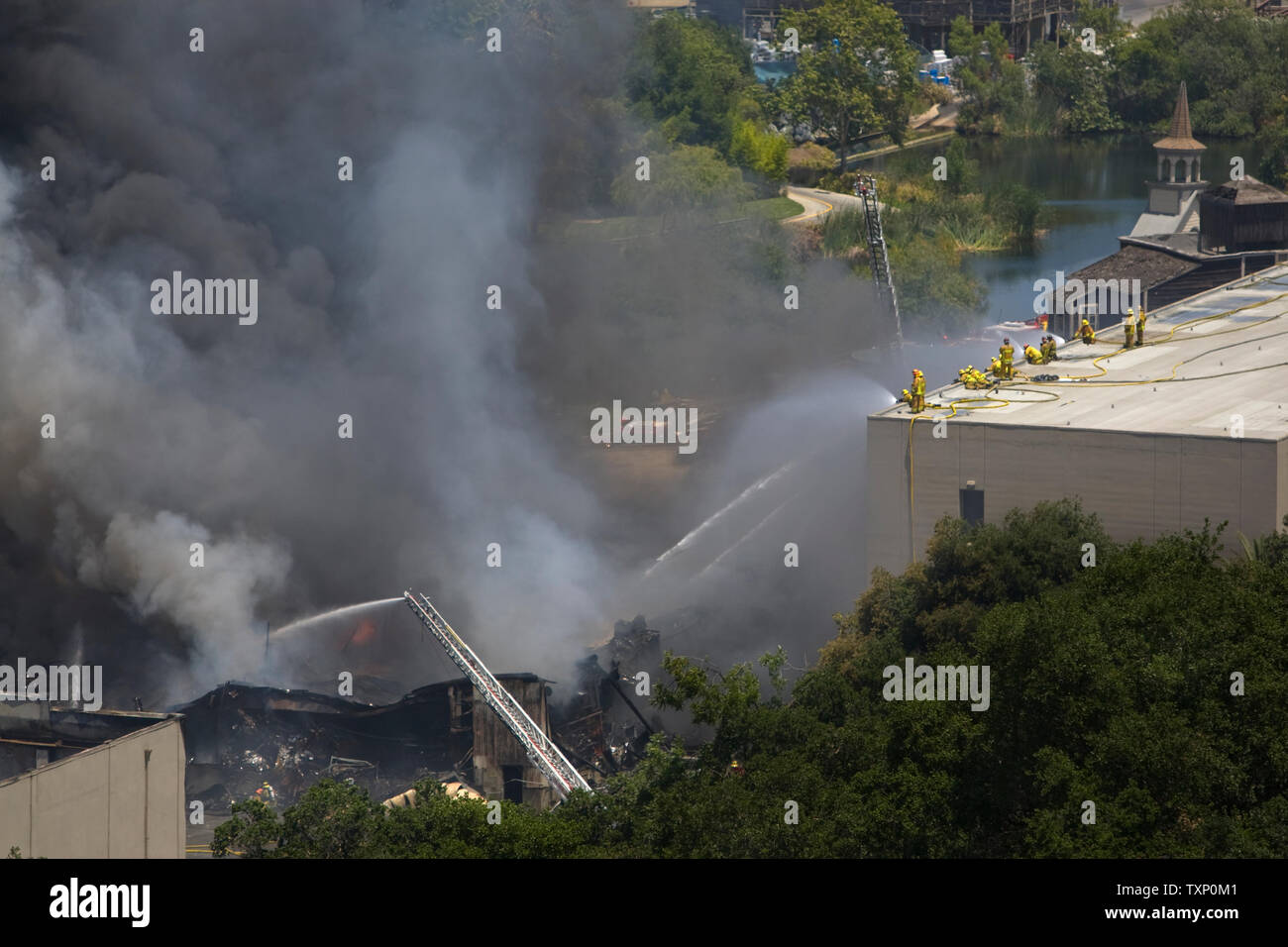 Firefighters try to extinguish the final flames of a fire that ...