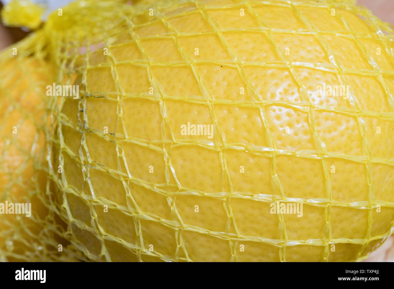 Lemons in nylon netting packaging. UK Stock Photo - Alamy