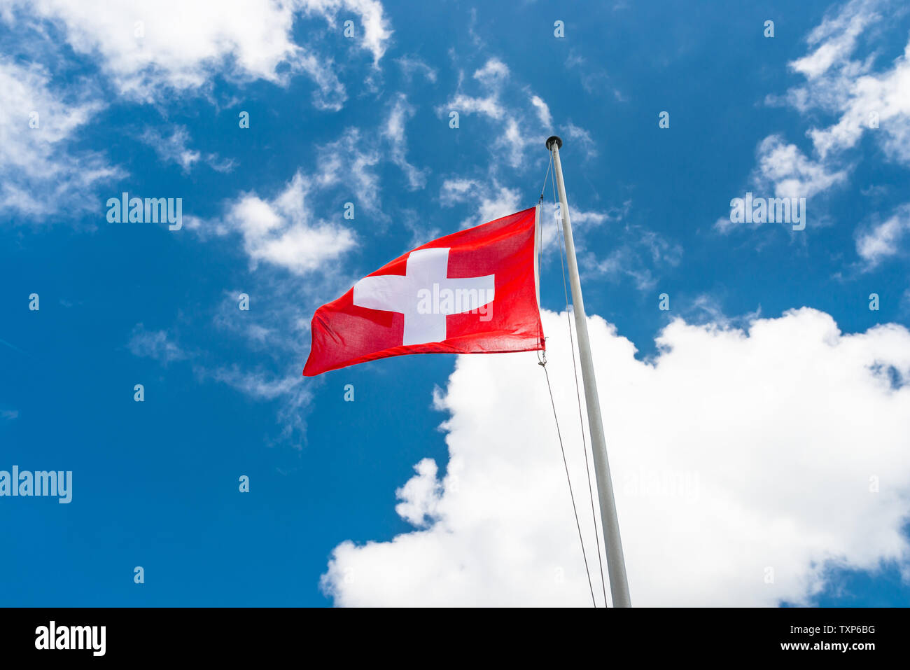 Waving in the wind to the left, the flag of Switzerland hanging on the ...