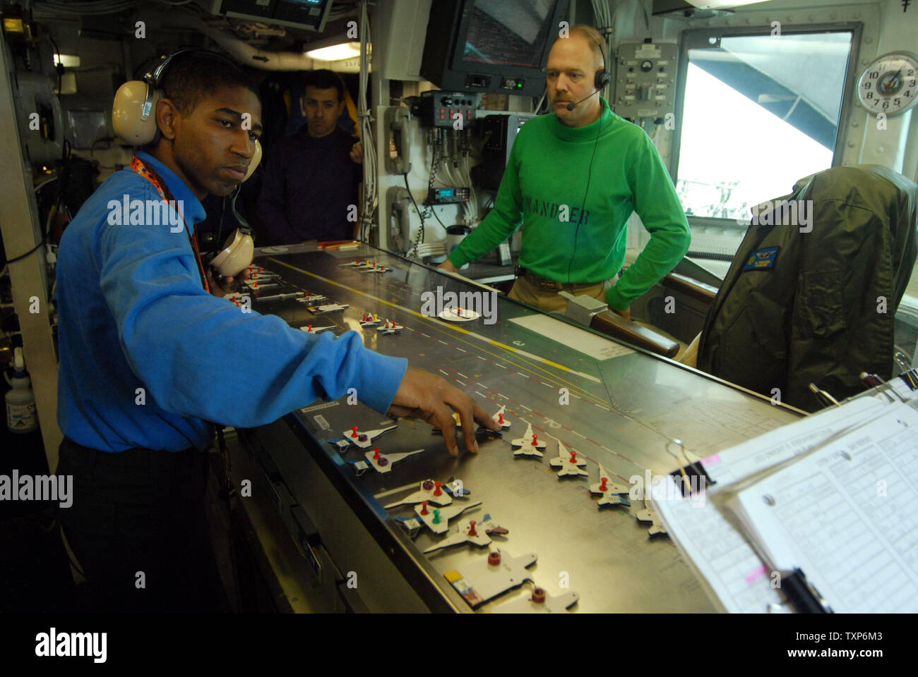 Military personnel work in the flight deck operations room aboard the ...