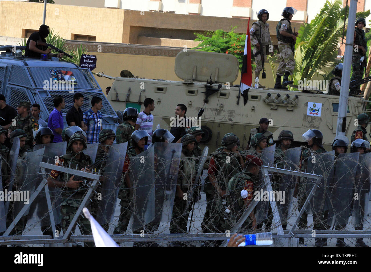 Egyptian soldiers stand guard as supporters of President Morsi ...