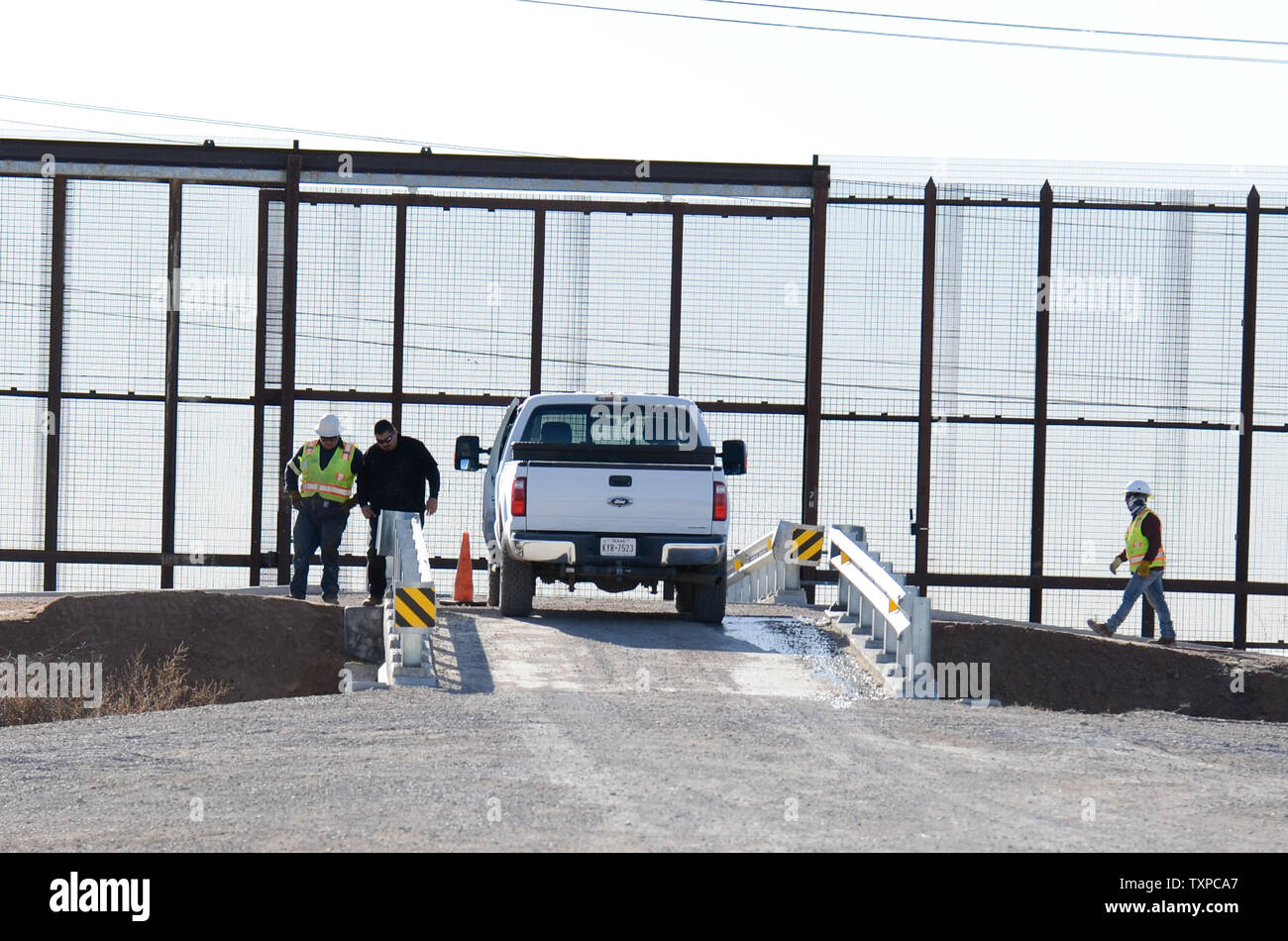 Border Patrol agents stand near a gate in the border fence that ...