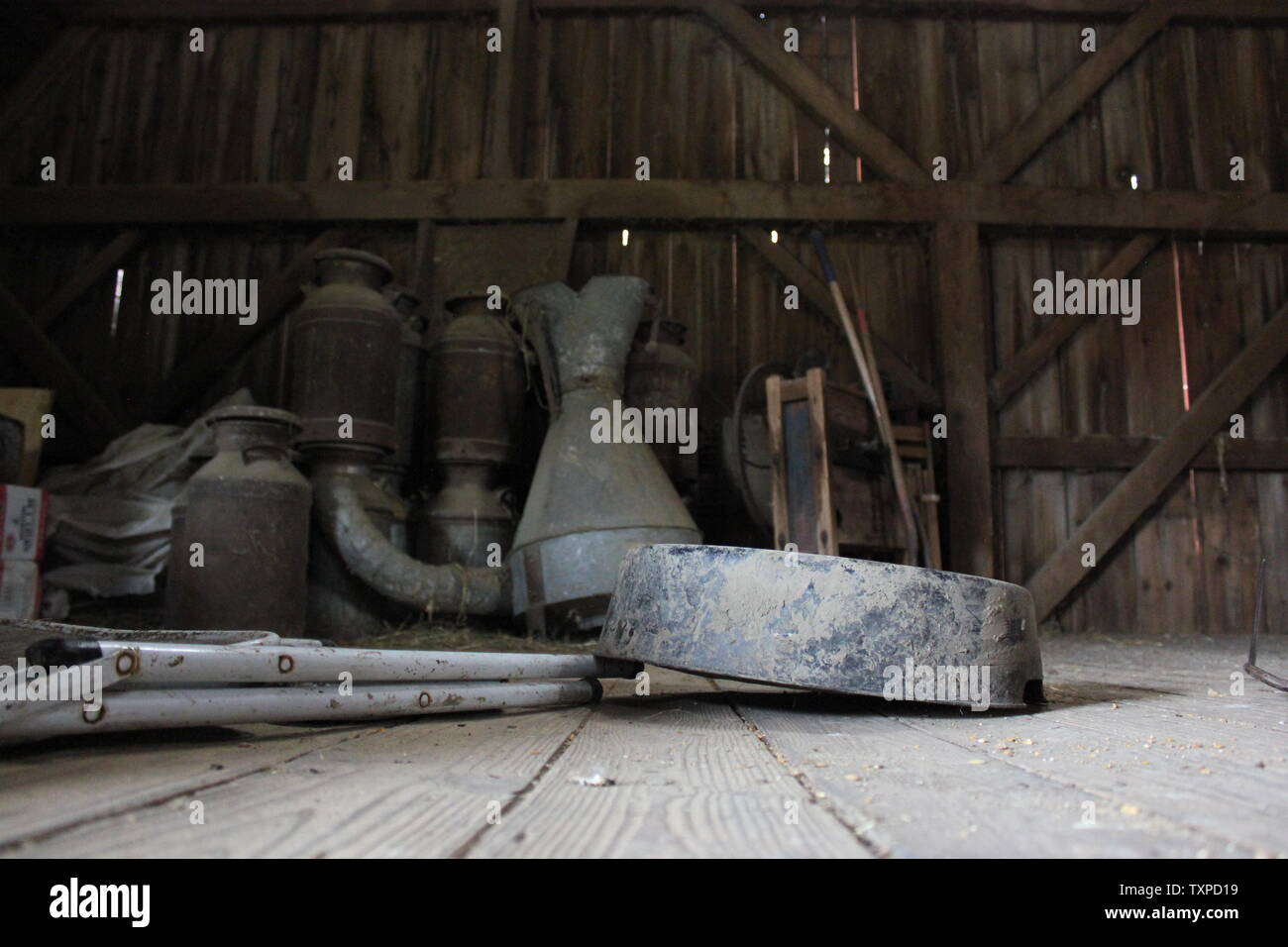 Farm tools including milk jugs stored inside the barn on the farm Stock ...