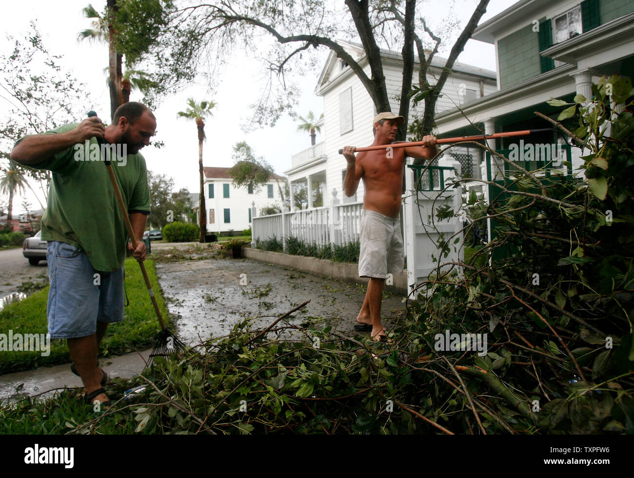 Joey Collier (R) and his friend William Hillebrand (L) start to clean up in the wake of ...