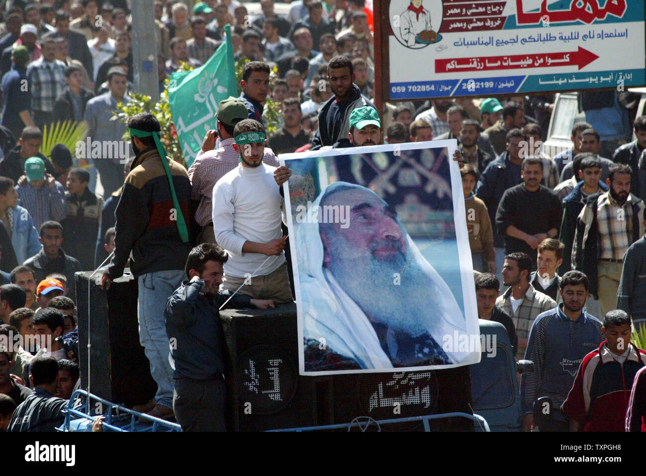 A large Palestinian crowd carries a poster of slain Hamas leader Sheikh ...
