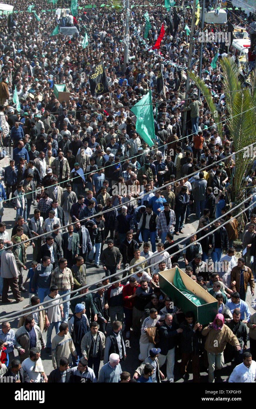 Palestinians carry the coffin of Sheikh Ahmed Yassin and five others ...