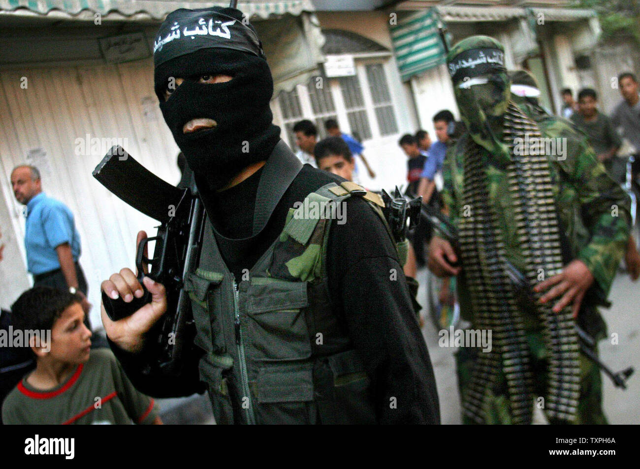 Palestinian militants and supporters of the Fatah movement demonstrate ...