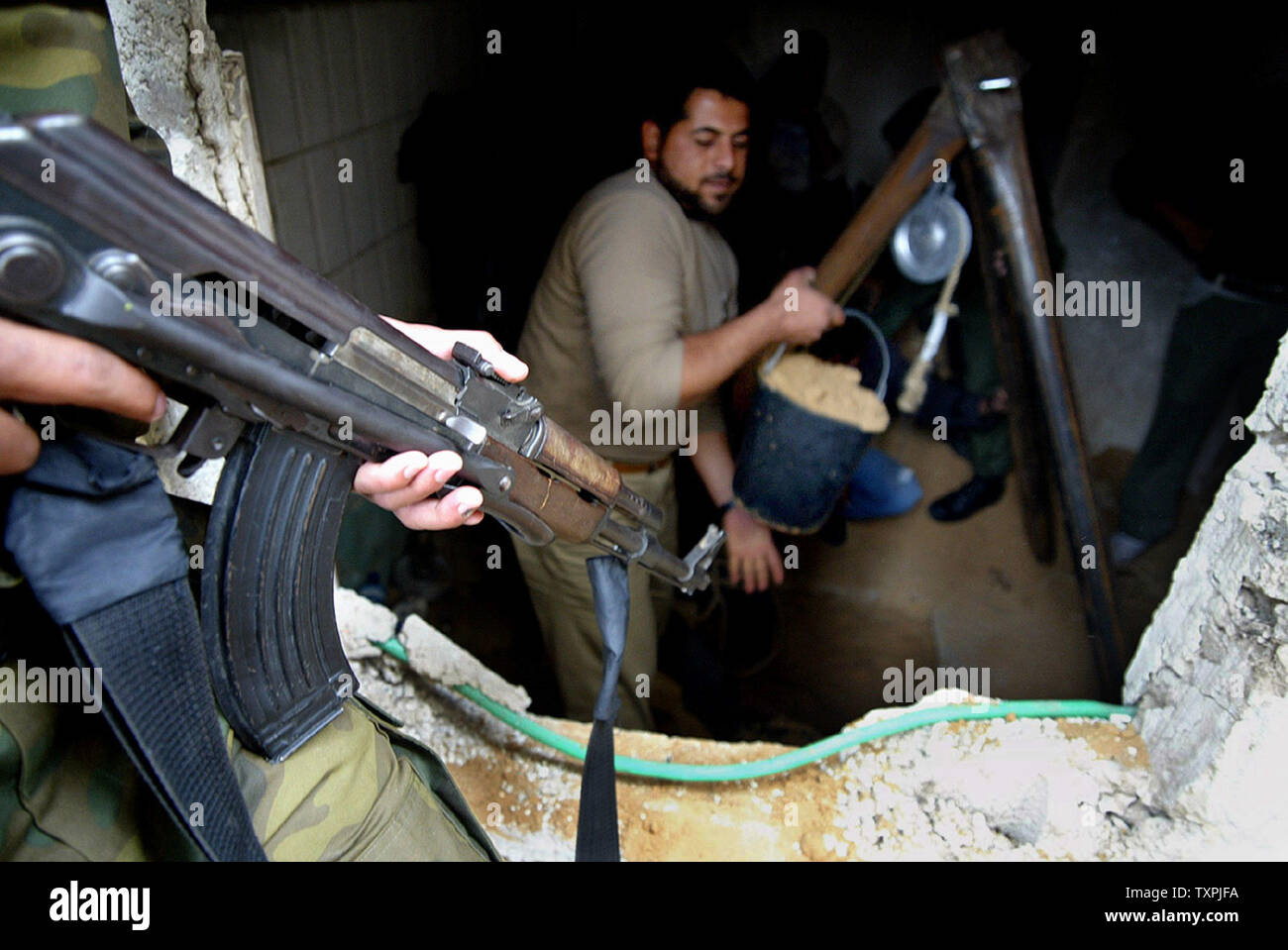 Palestinian police officers examine a tunnel, allegedly built and used ...