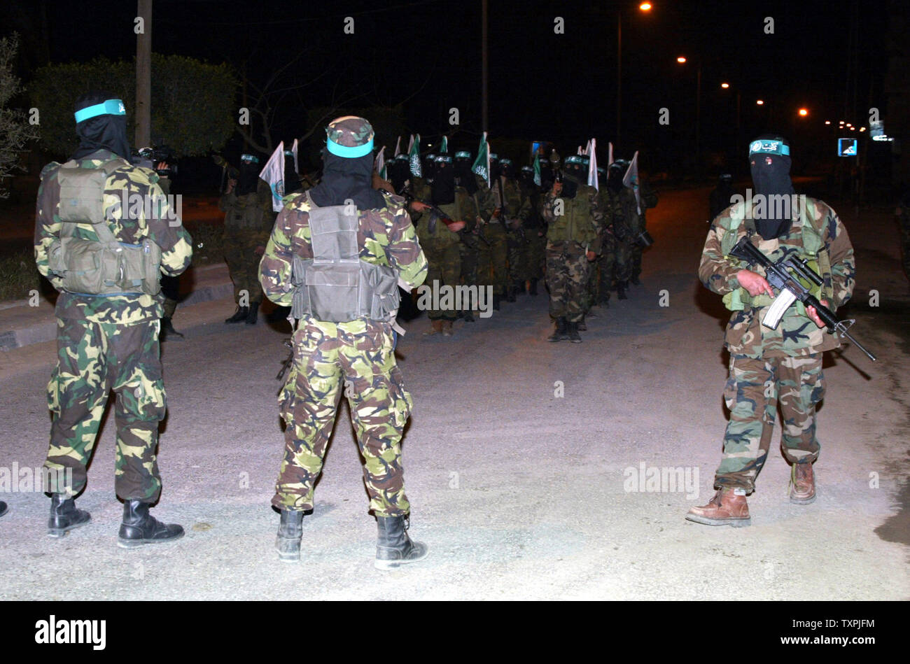 Masked fighters of the Islamic Resistance Movement (Hamas) take ...
