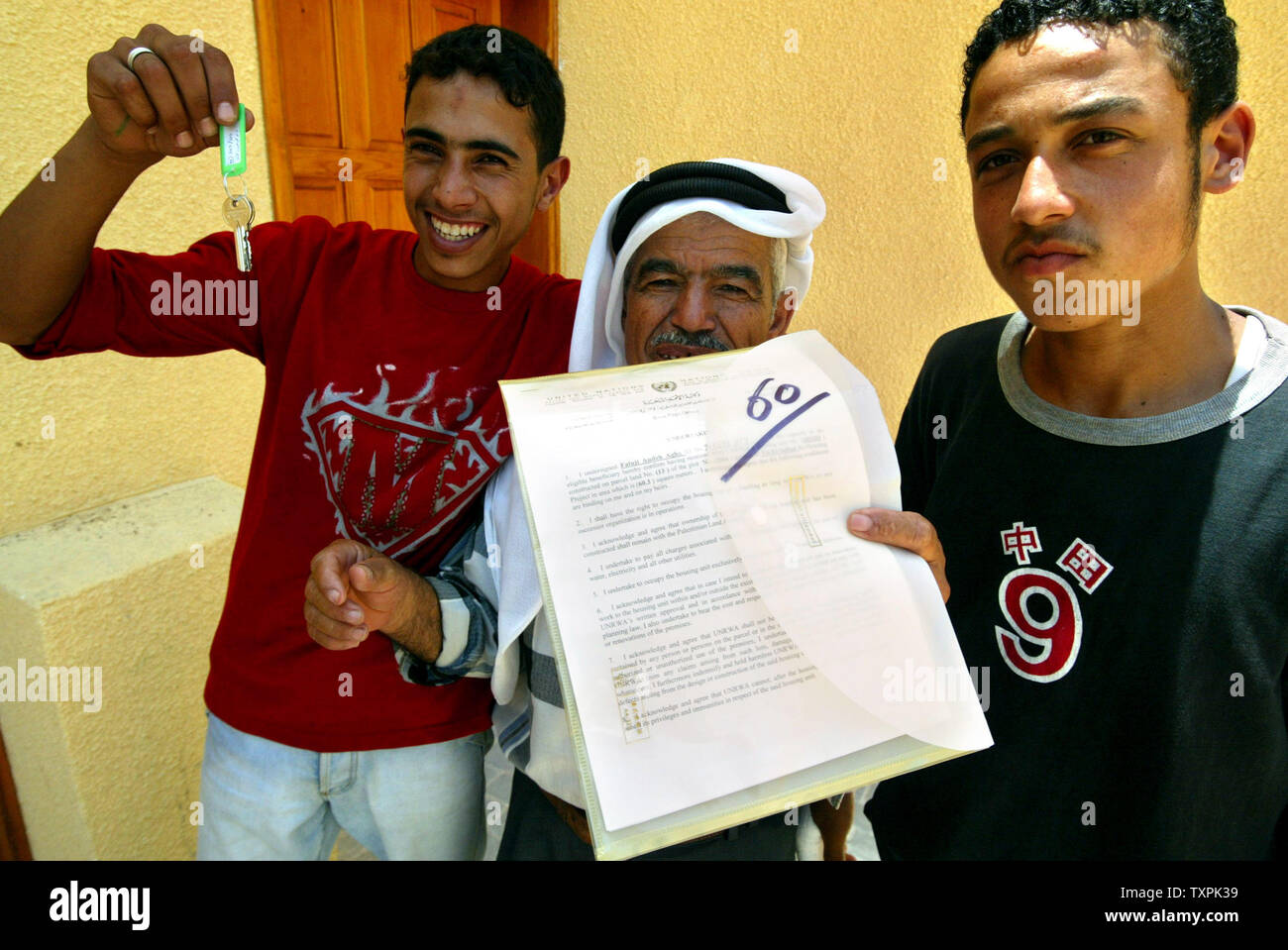 Palestinians display keys and paperwork after the handing over of new ...