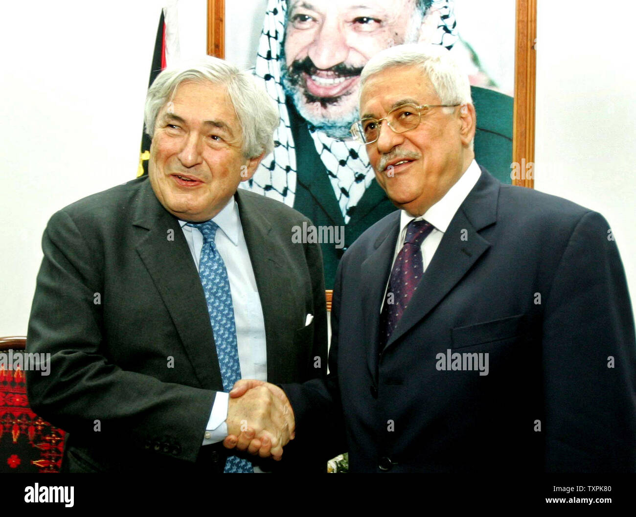 Palestinian President Mahmoud Abbas (R), shakes hands with ...