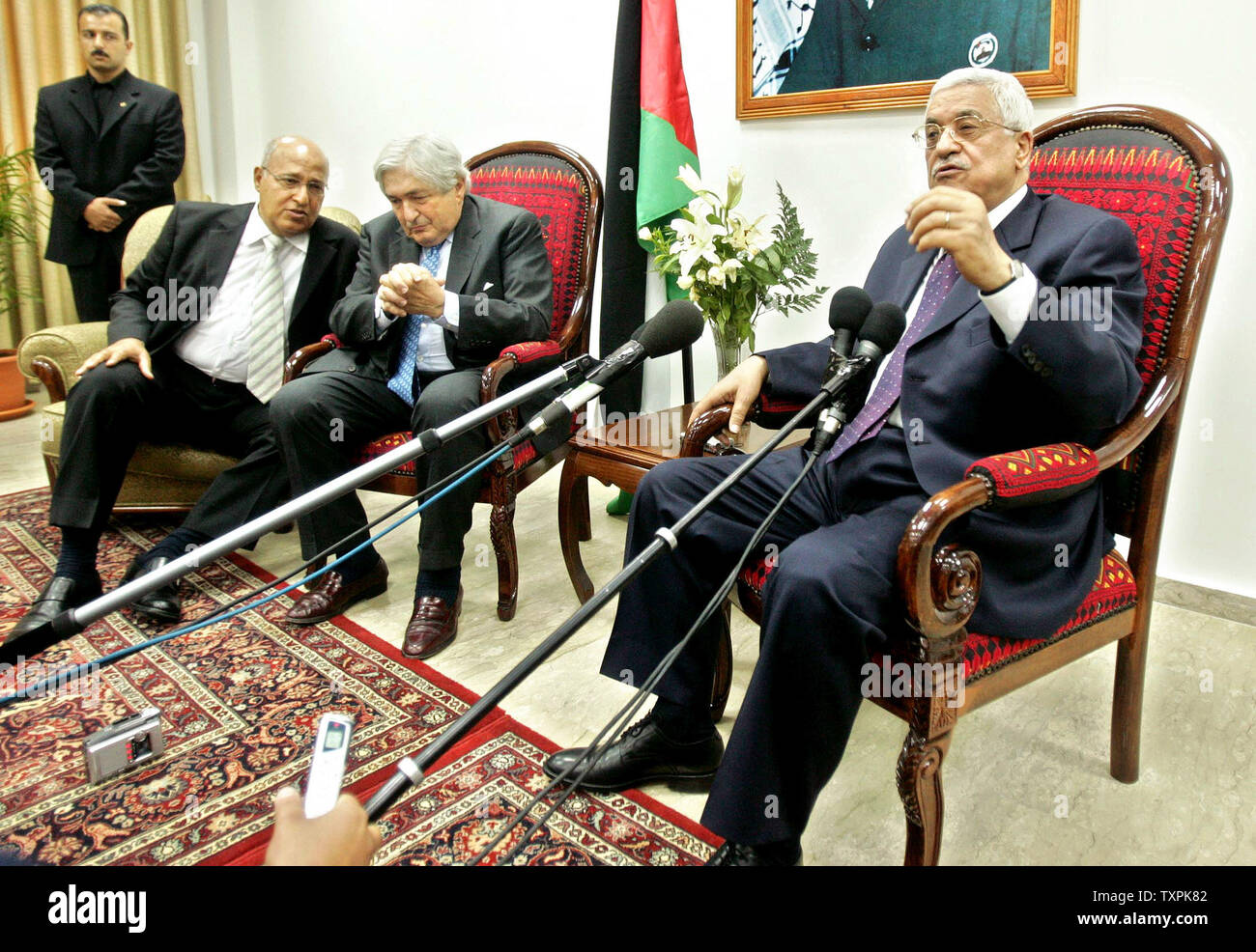Palestinian President Mahmoud Abbas (R), talks to reporters as ...