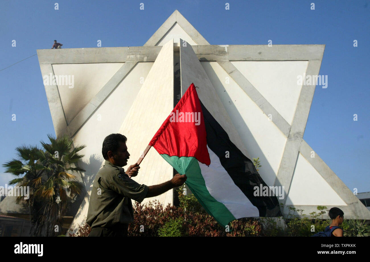 A Palestinian policemen holding a Palestinian flag walks by the Yamit ...