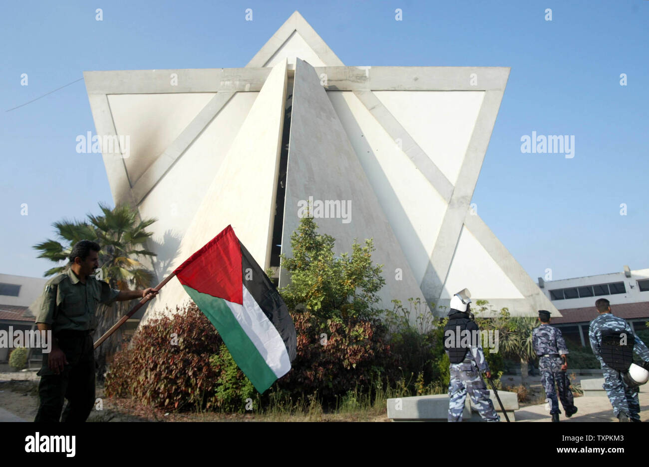 A Palestinian policemen holding a Palestinian flag walks by the Yamit ...