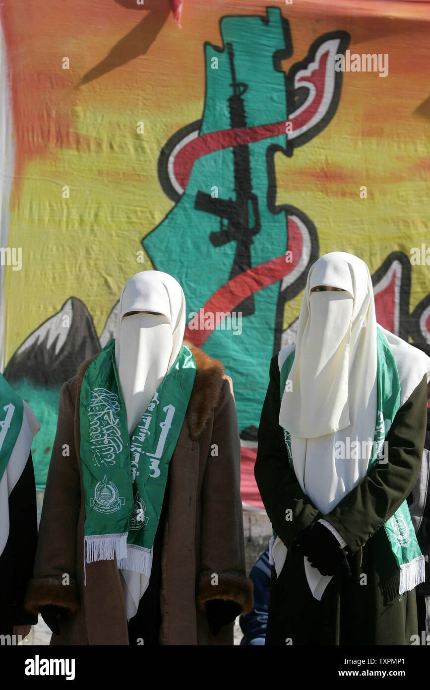 Palestinian women stand in front of Hamas and Sharon graffiti, during a ...