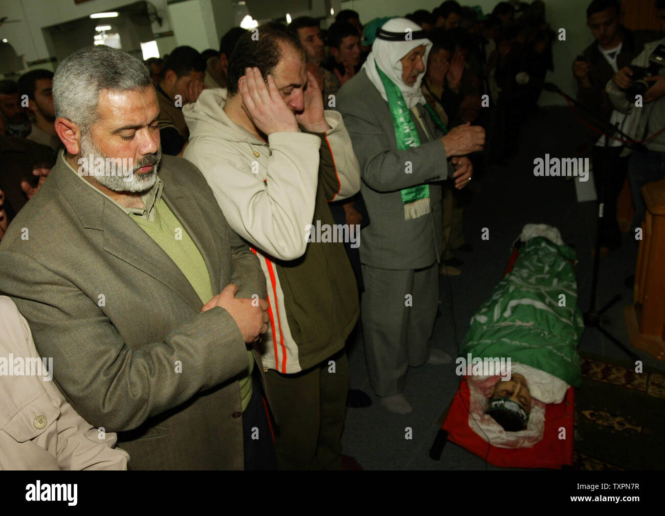 Incoming Hamas Prime Minister Ismail Haniyeh, left, attends the funeral ...