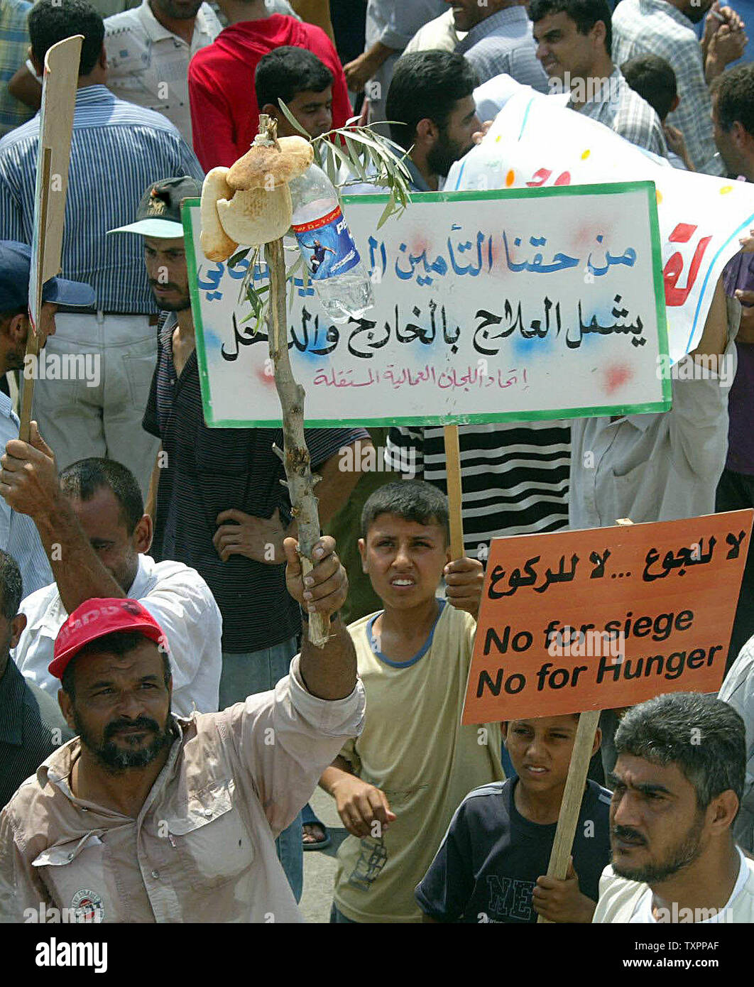 Unemployed Palestinians, hold pieces of bread and a branch of an olive ...