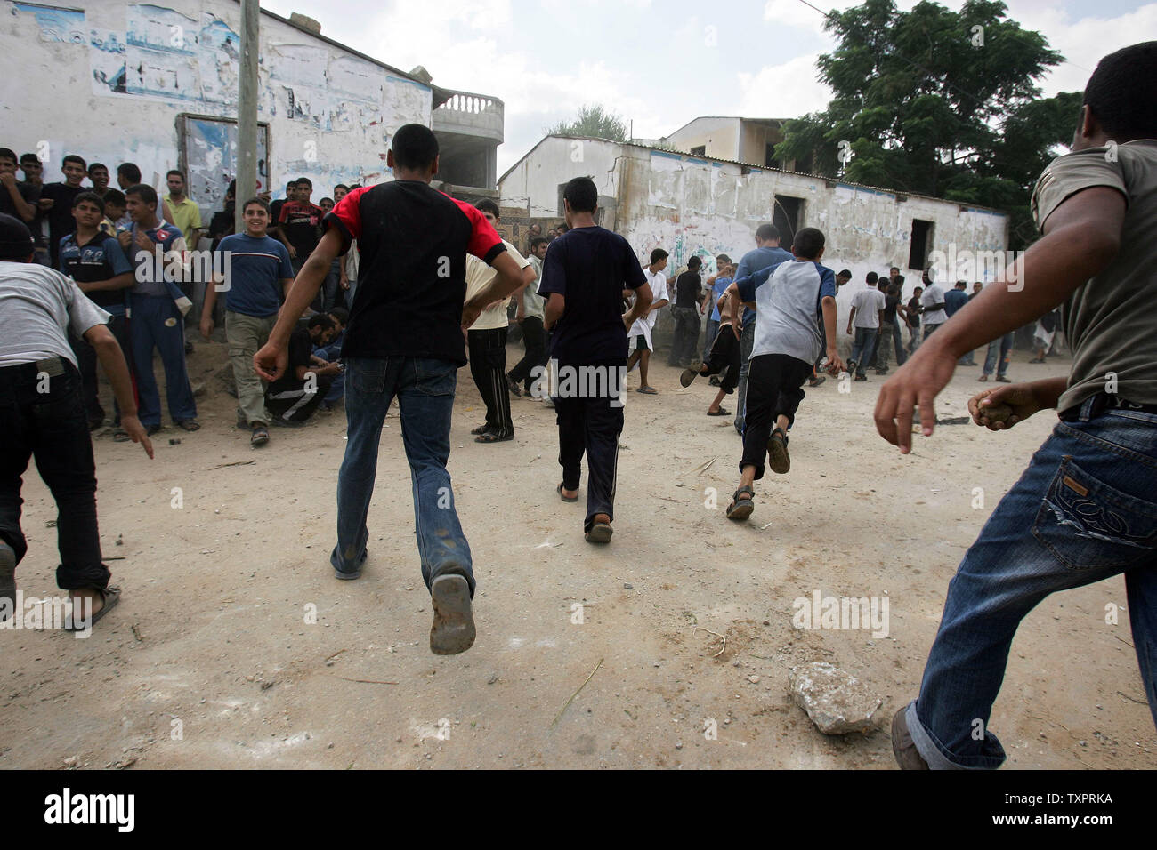 Palestinian stones throwers take cover from an Israeli tank (not ...