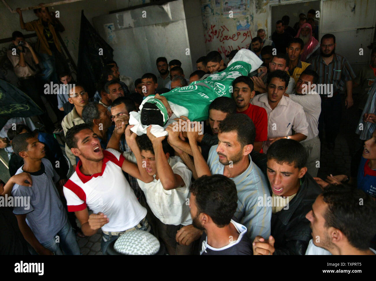 Palestinian mourners carry the body of Hamas militant Hazem Asfoor ...