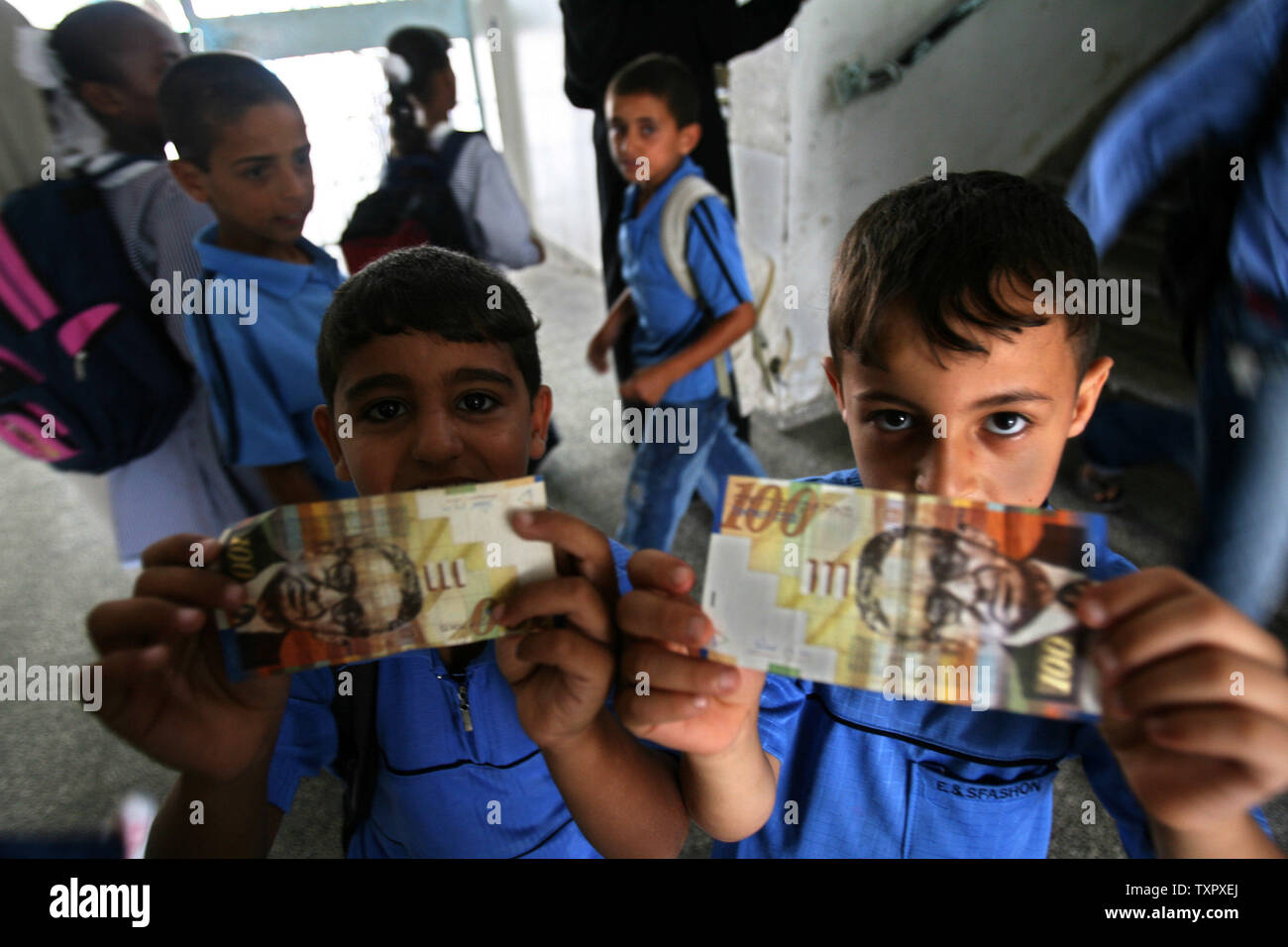 Palestinian primary school students display the one hundred New Israeli ...