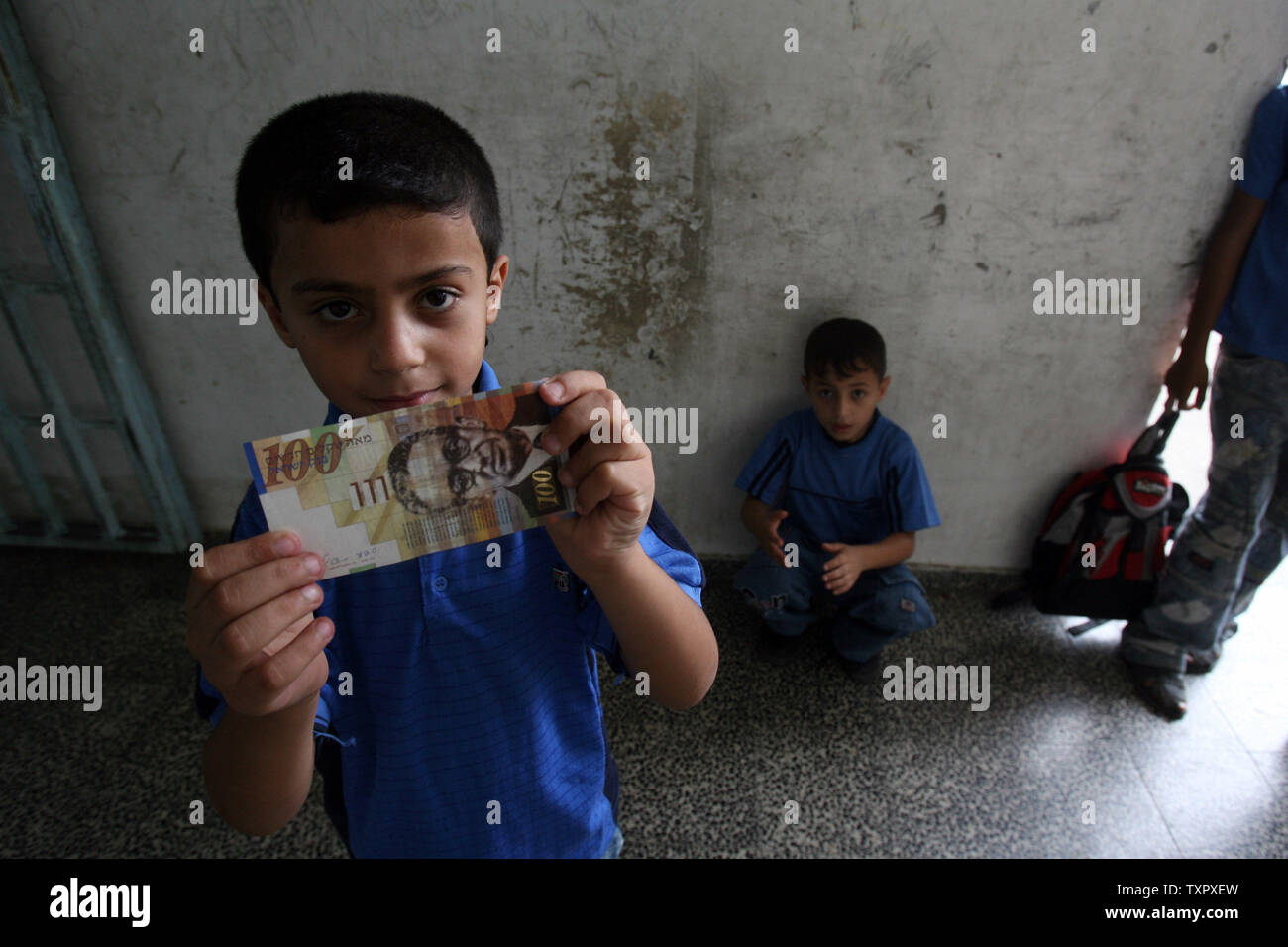 A Palestinian primary school student displays the one hundred New ...