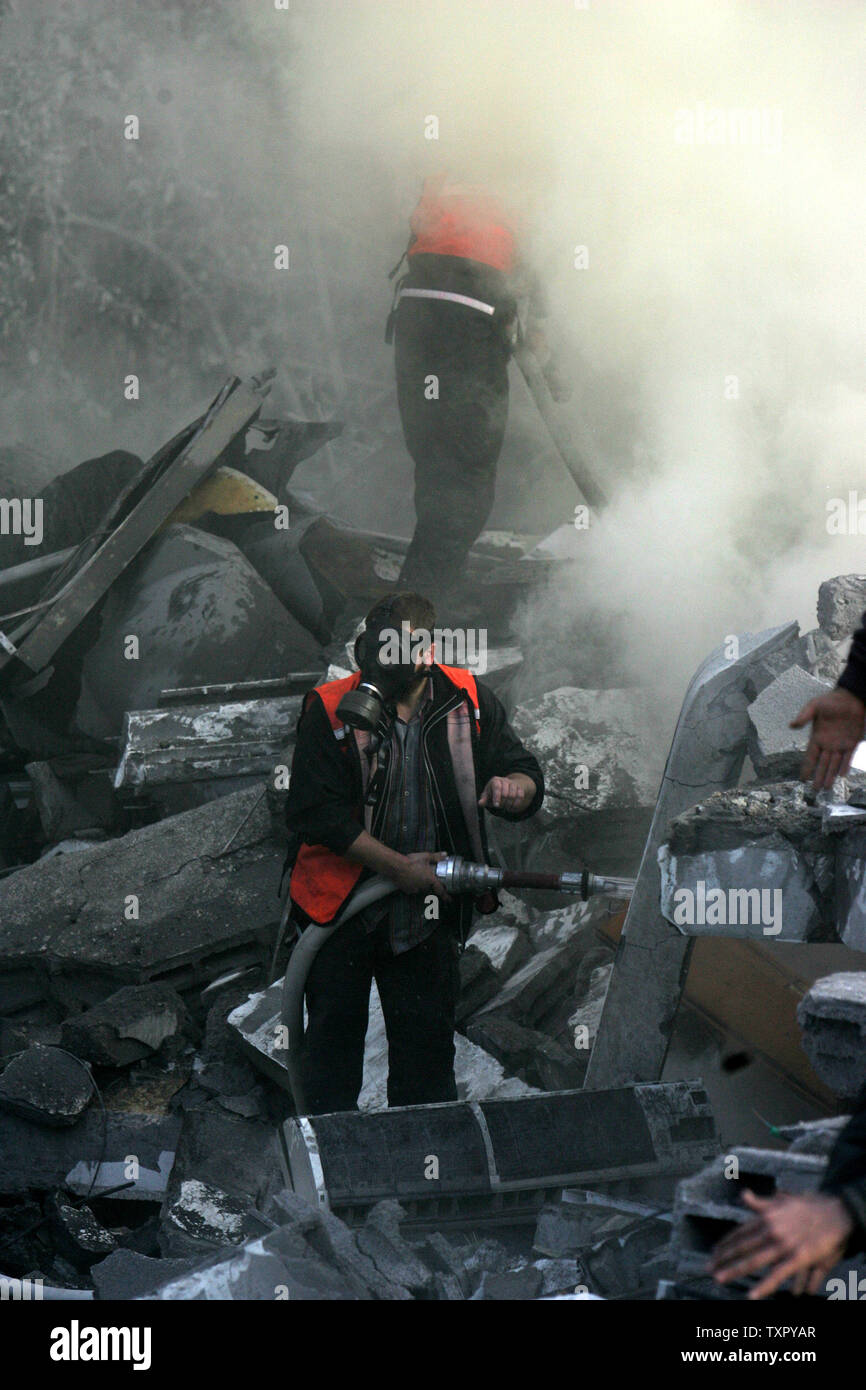 Palestinian firemen hose down the destroyed house of Hamas senior ...