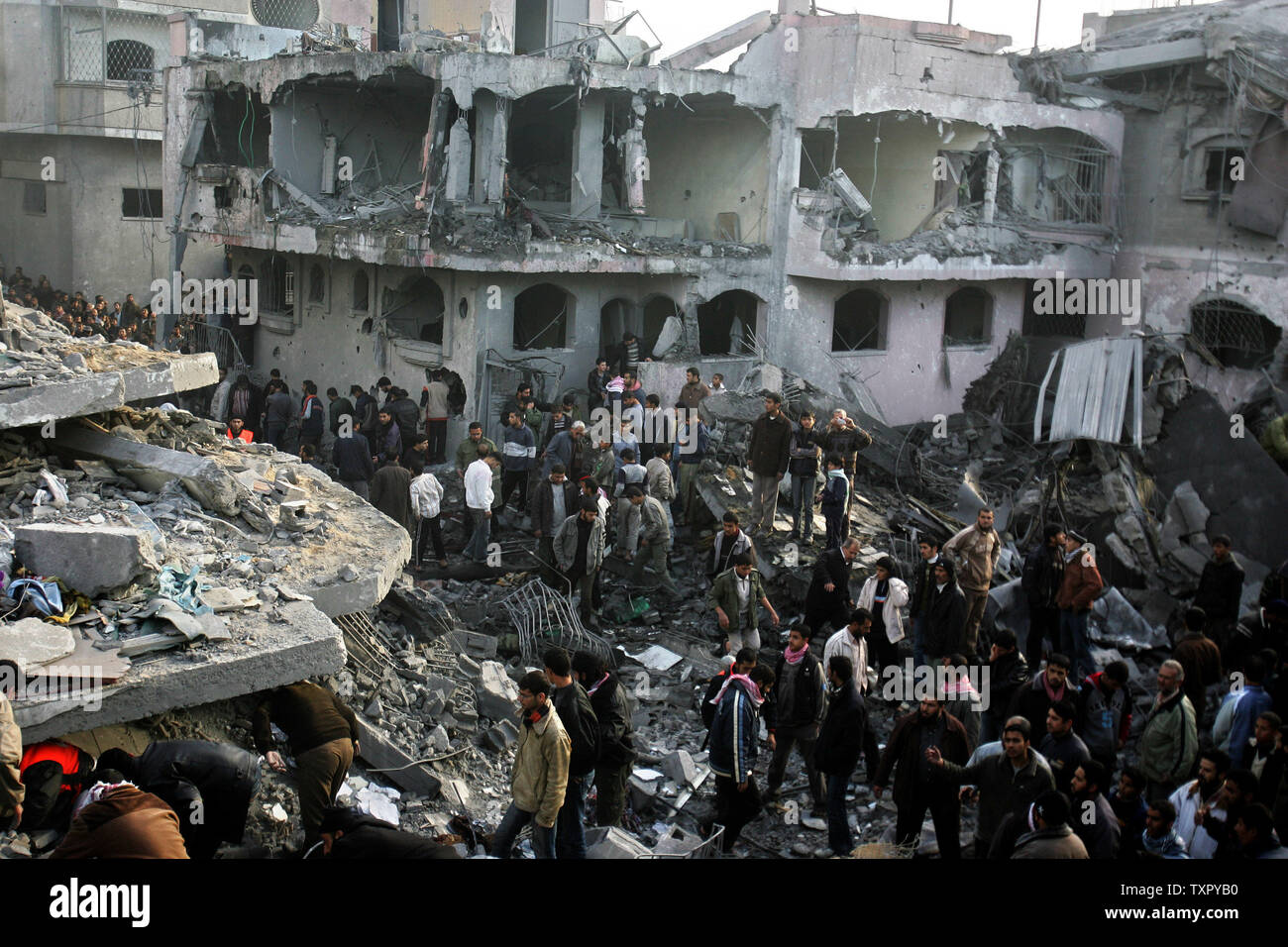 Palestinians search for bodies in the rubble of the destroyed house of ...