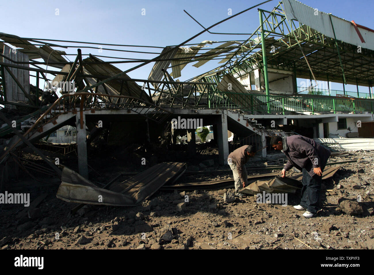 Palestinians inspect the damage to a football stadium following Israeli ...