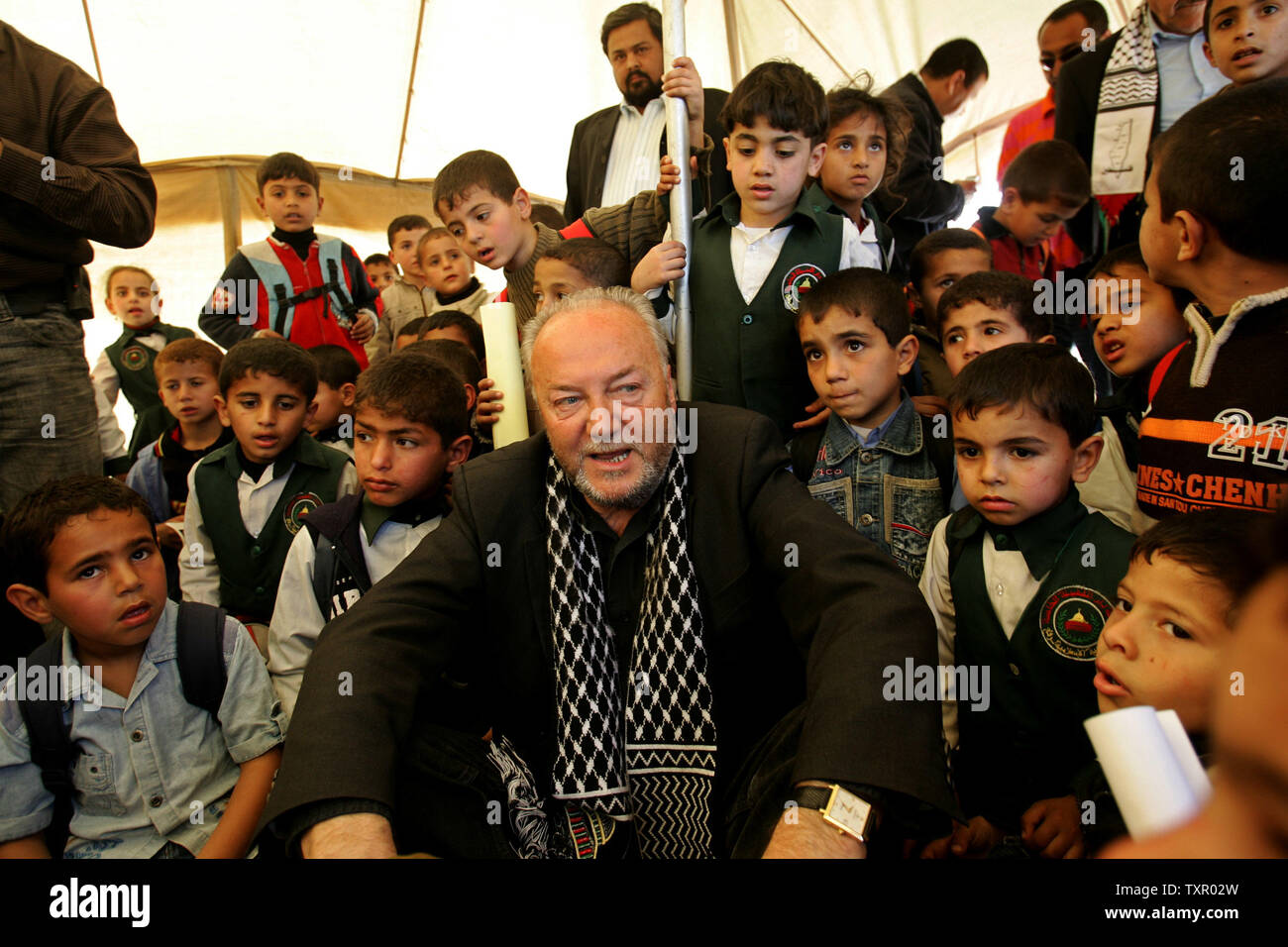 British lawmaker and activist George Galloway (C) sits among ...