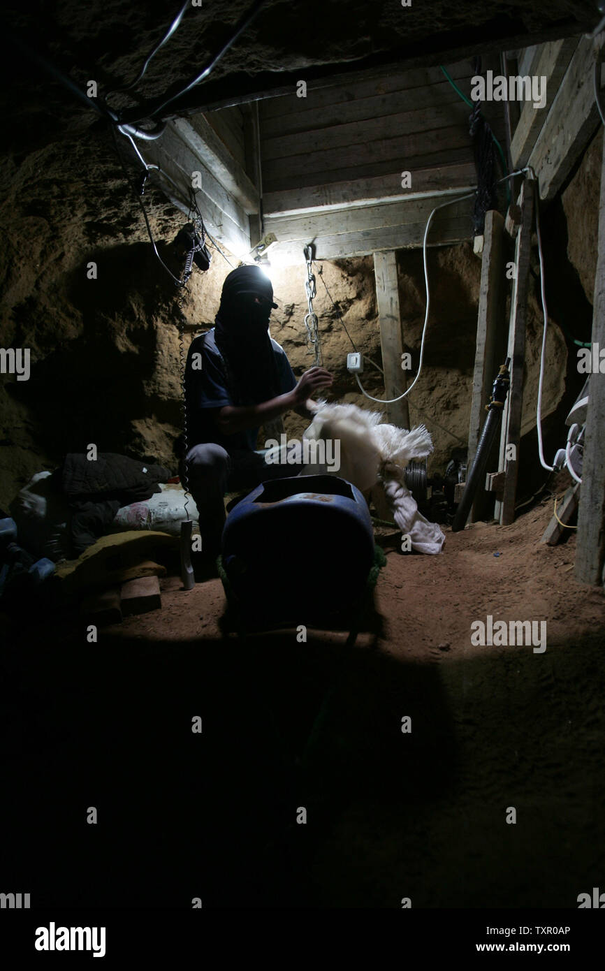 A Palestinian smuggler inspects a tunnel that runs under the border ...
